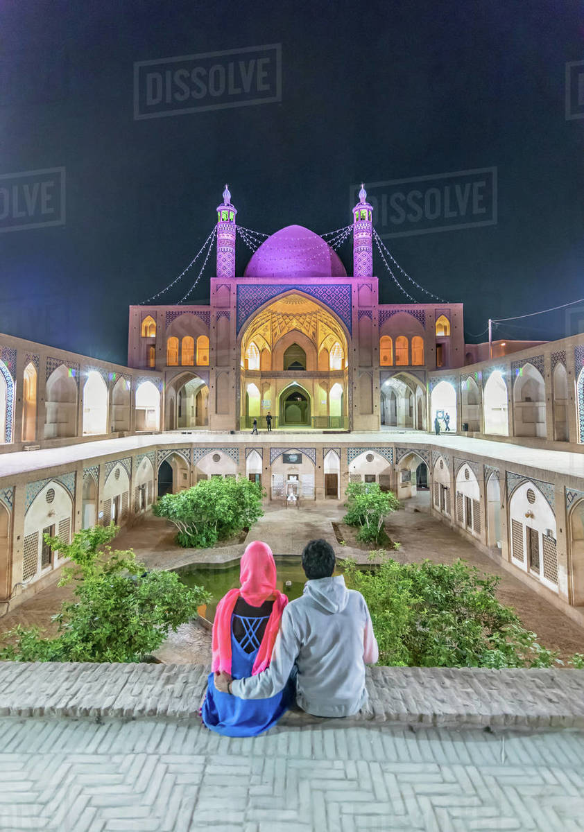 Back view of young Muslim couple sitting in courtyard of beautiful ...