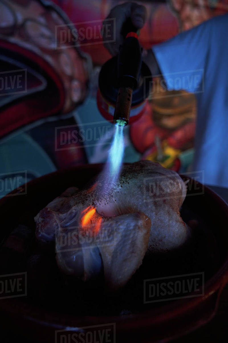 Whole fresh chicken during processing with flamethrower with bright gas ...