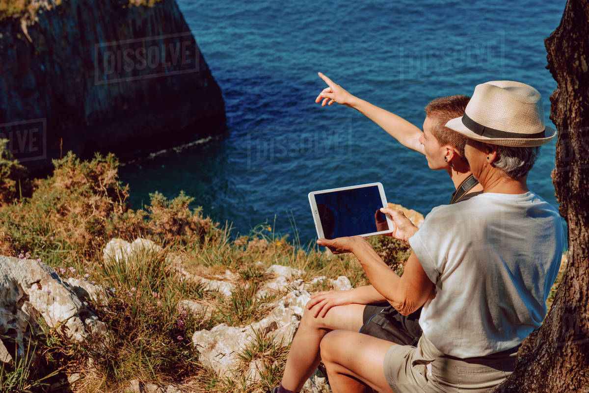 Side view of touristic women exploring sightings at rocky coast with ...