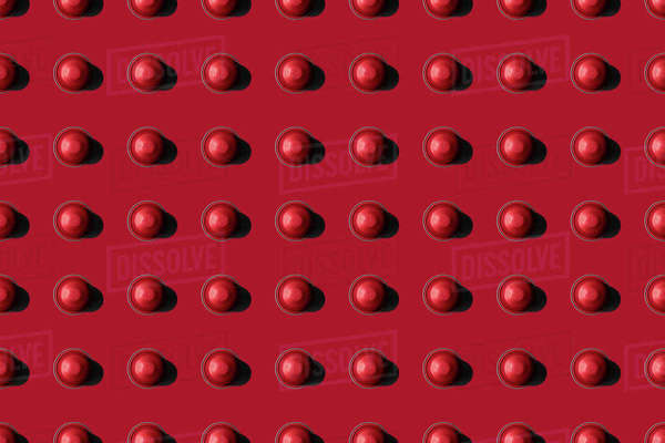 Top view of red coffee pods placed in even rows as seamless pattern on ...