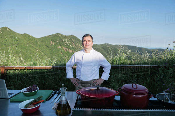 Middle aged male chef standing while gets ready to cooking healthy dish ...