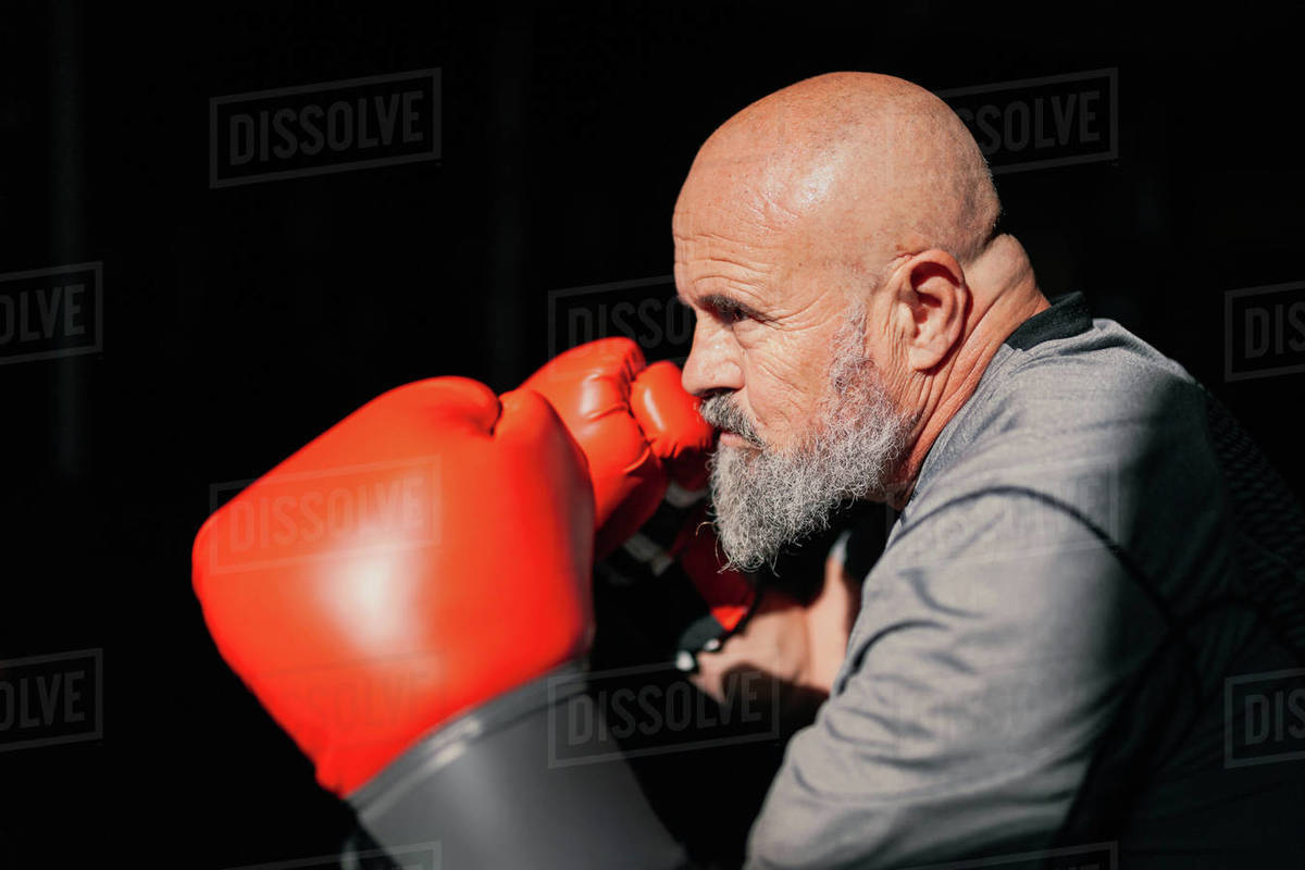 Side view portrait of powerful serious adult mature male boxer in red ...