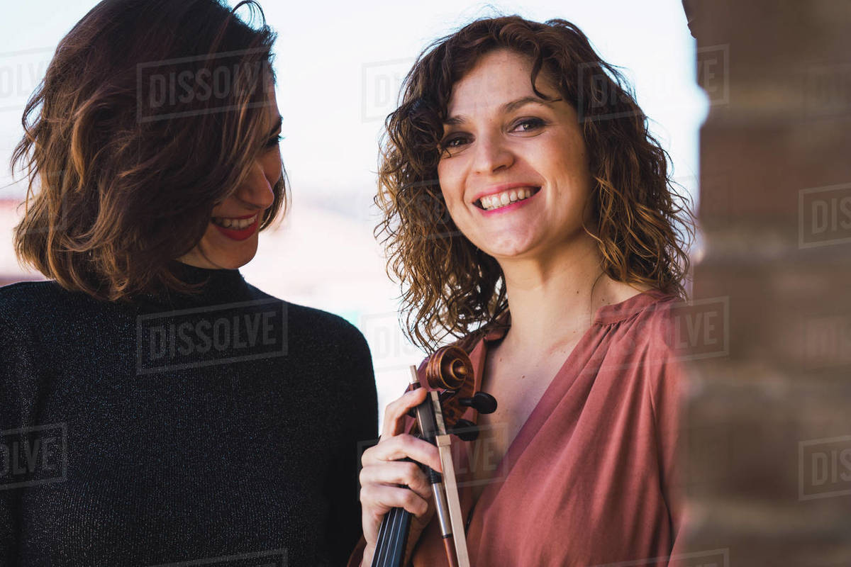 Two women musician smiling outdoors - Stock Photo - Dissolve