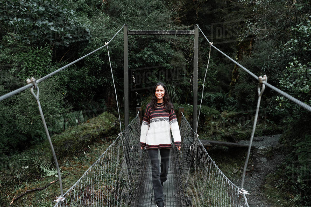 Cheerful young female standing on bridge in forest - Royalty-free Stock ...