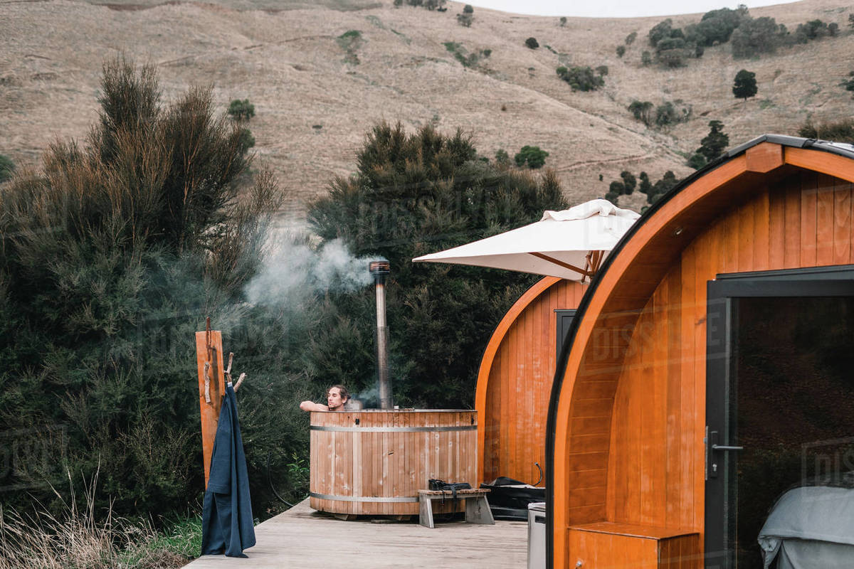 Intrepid pods for rest and hot tub with shirtless young man in Te Wepu ...