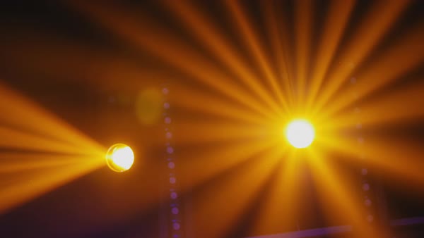 Two spotlights rotate on the wall, the rays are painted in orange ...