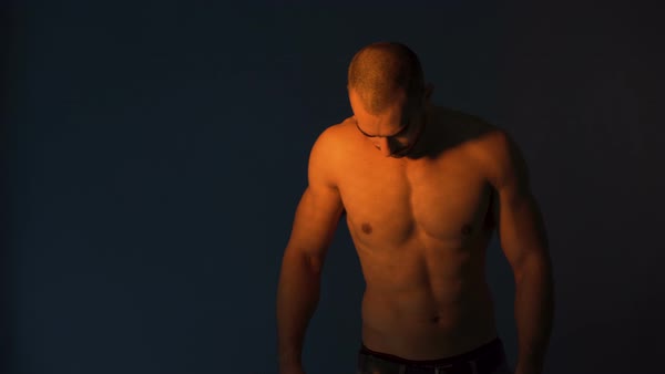 Male Fitness Model Flexing muscles, isolated on blue background. Studio ...