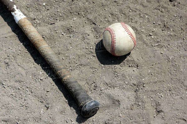 Close up of a baseball and bat in dirt - Stock Photo - Dissolve