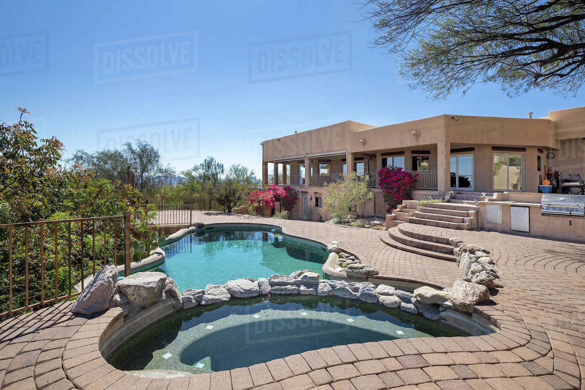 Swimming pool and terraced patio at a luxury home in a desert ...