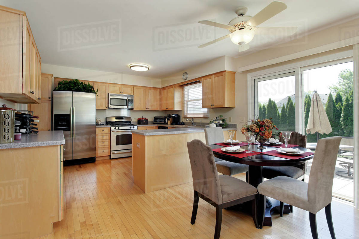Kitchen in suburban home with eating area and doors to patio. - Stock ...