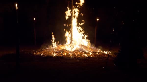 A symbolic and traditional characters dancing near a bonfire during ...