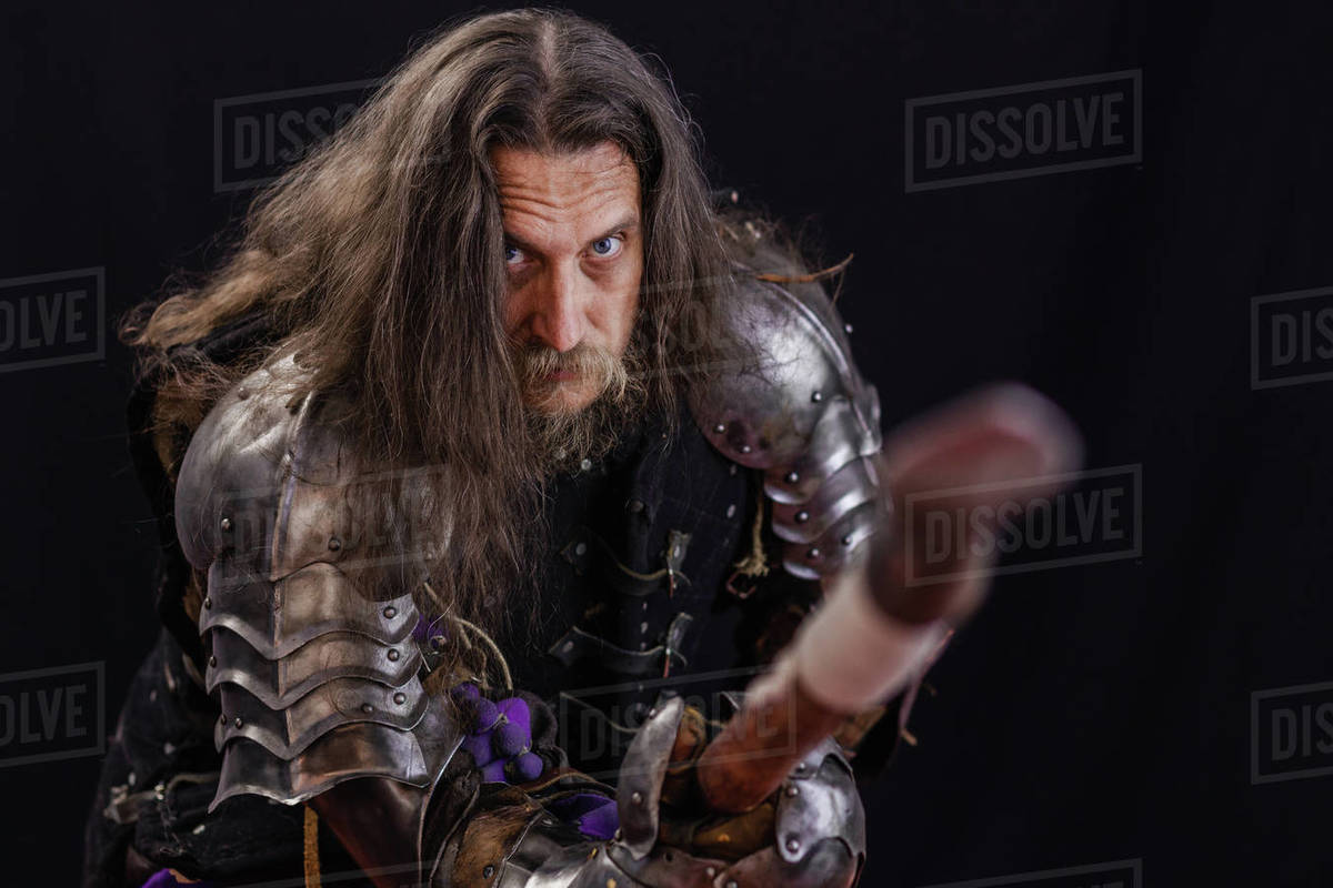 A medieval knight in armor strikes. Charismatic actor with mustache and ...