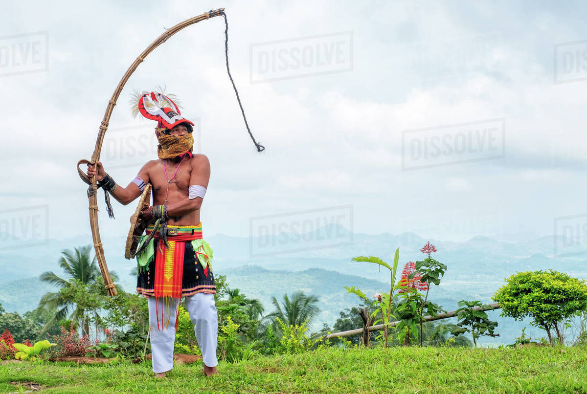Caci man performing a traditional whip dance with bamboo shield and ...