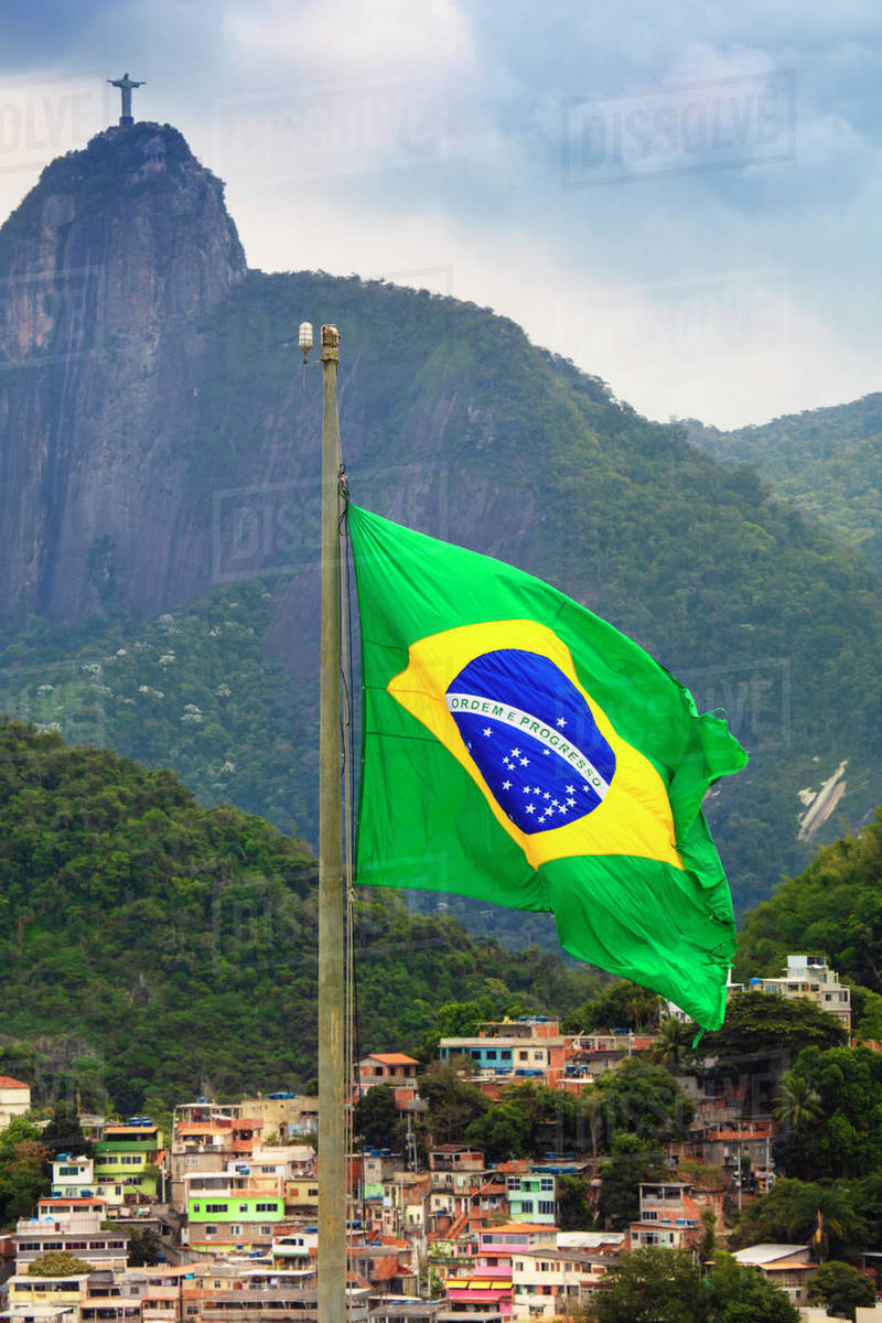 Brazilian flag with a favela and the Christ statue on Corcovado peak in ...