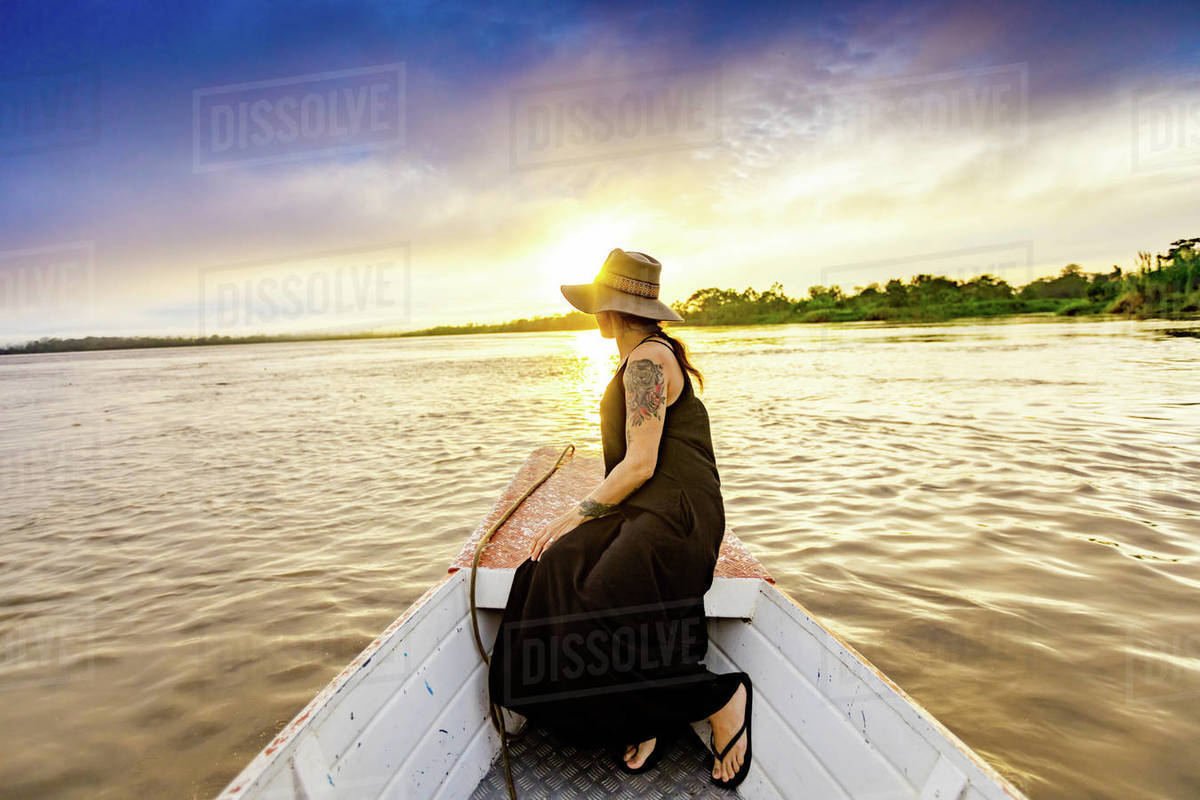 Woman enjoying sunset on the river, Amazon River, Peru, South America ...