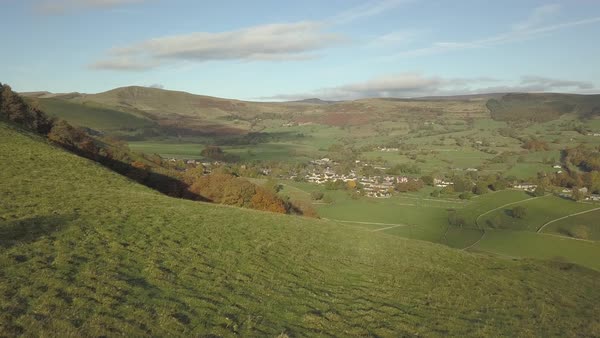 Aerial shot over fields towards Castleton in autumn, Hope Valley, Peak ...