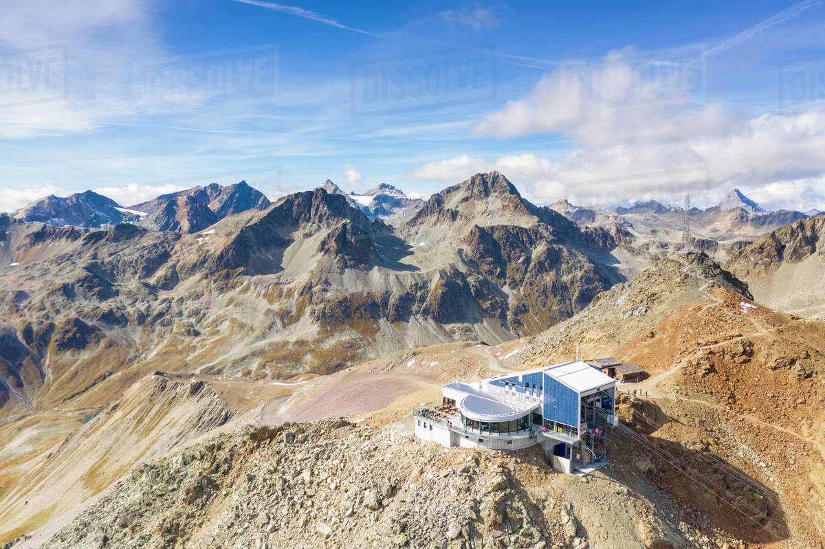 Aerial by drone of cable car station on top of the rocky peak of Piz ...