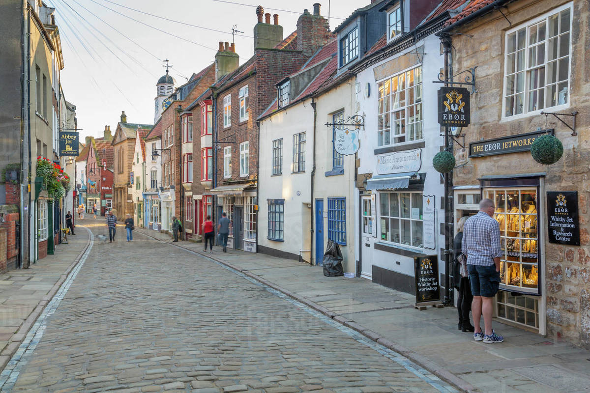 View of shops on traditional cobbled street in historic town centre ...