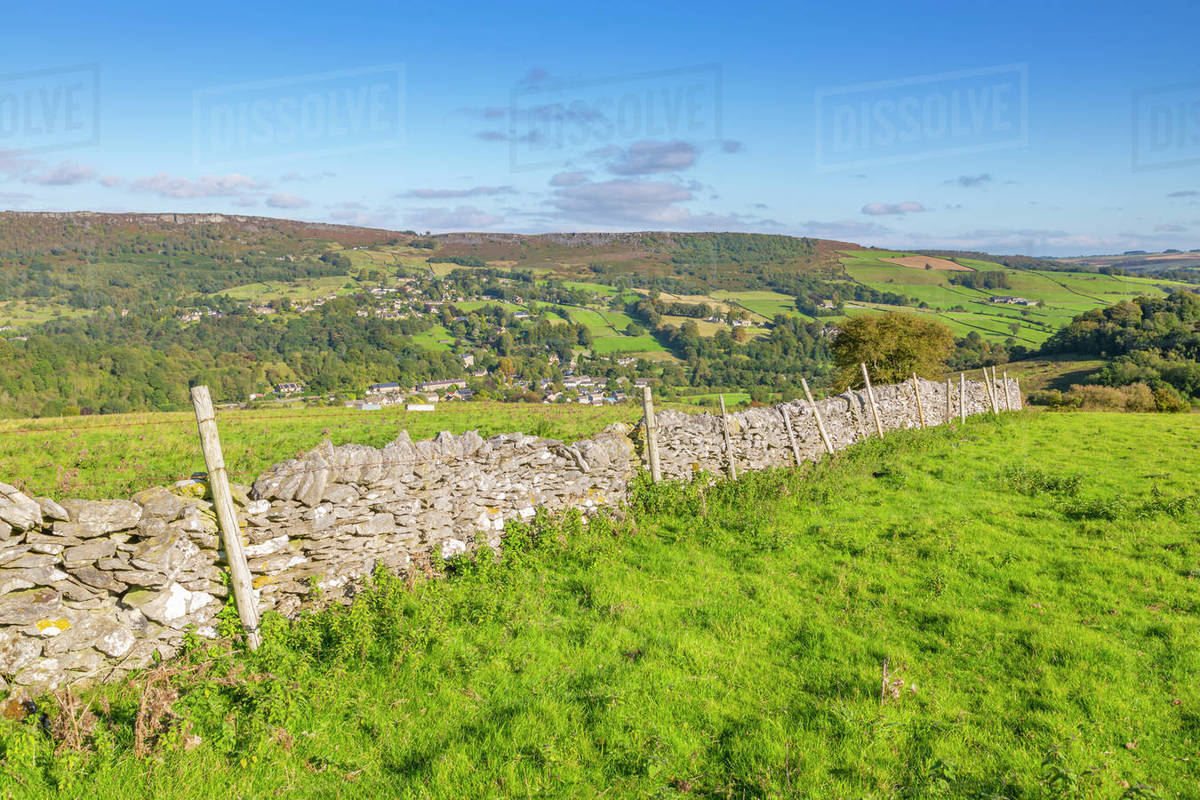 View of dry stone wall and Calver Village overlooked by Curbar Edge ...