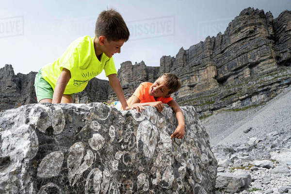 Smiling little boys looking at fossils on rocks, Orti della Regina ...