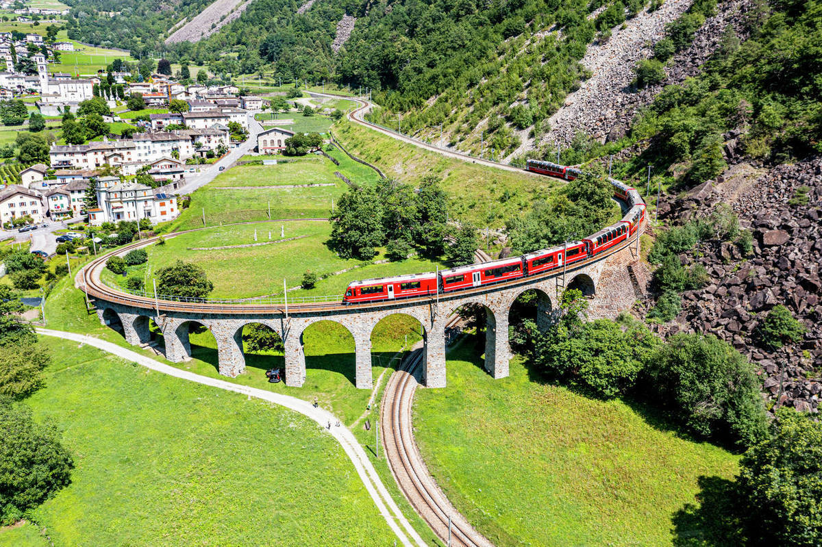 Aerial of a Train crossing the Brusio spiral viaduct, UNESCO World ...