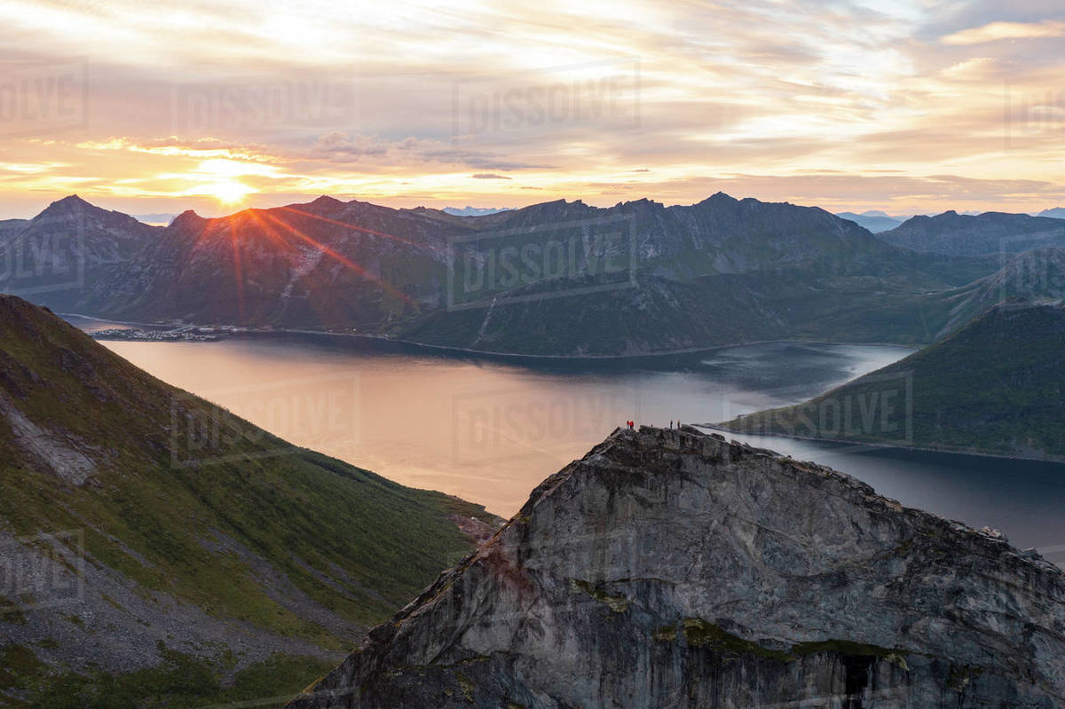 People admiring the sky at dawn standing on mountain top above the ...