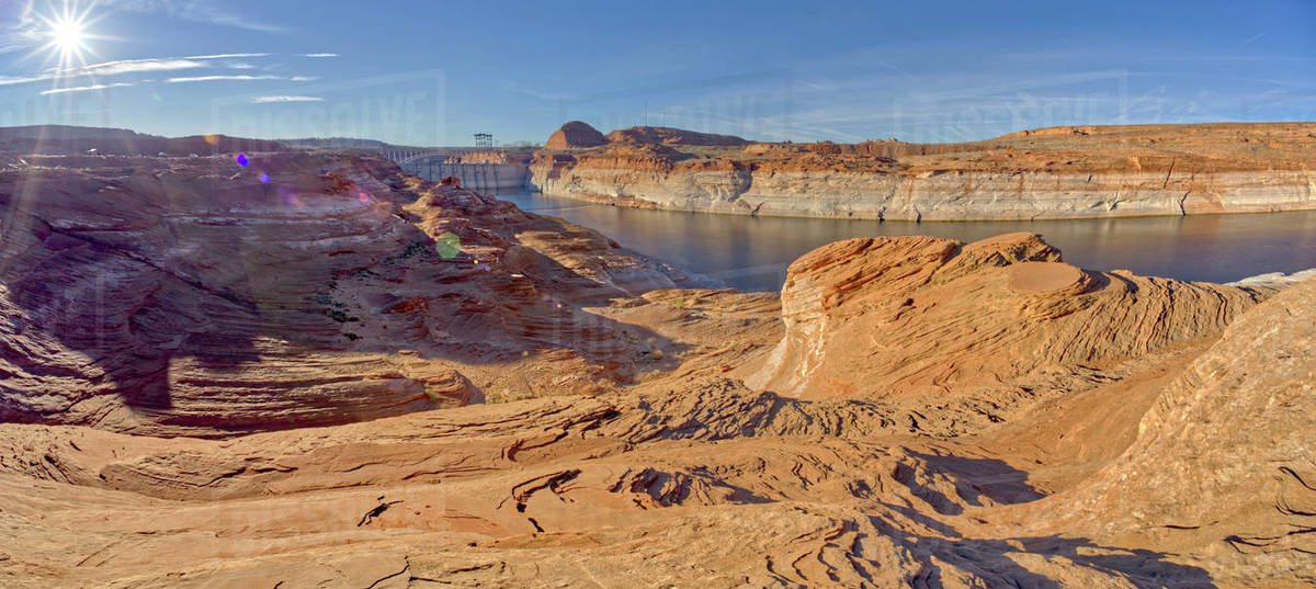 Wide angle view of Glen Canyon Dam from the wavy sandstone mesa of an ...