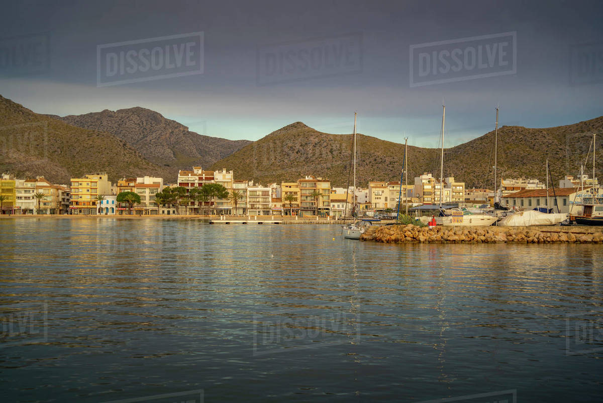 View of sunrise reflecting on hotels and bars in Port de Pollenca, Port ...