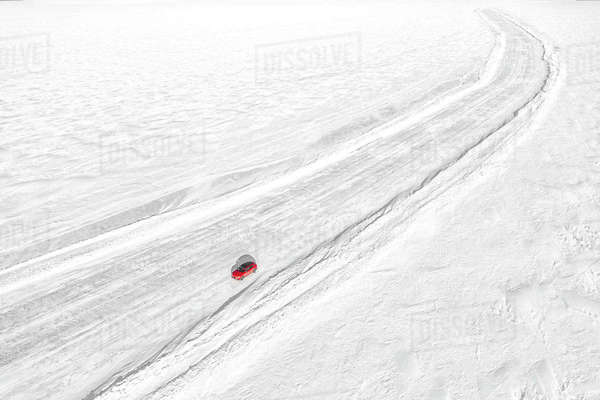 Aerial view of car traveling on empty ice road on the frozen sea, Lulea ...