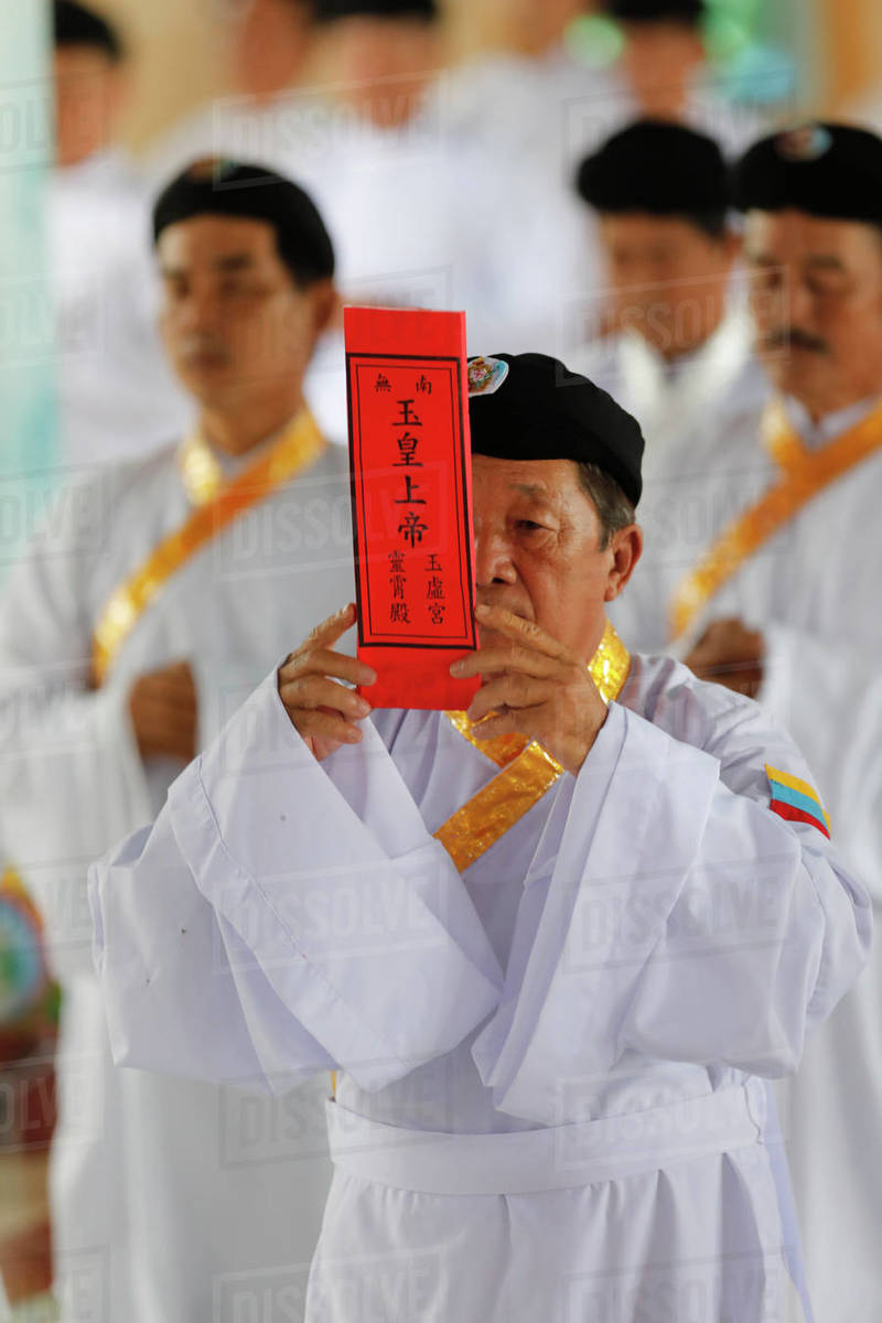 Cao Dai temple, Caodaist worshippers at ceremony, meditating followers ...