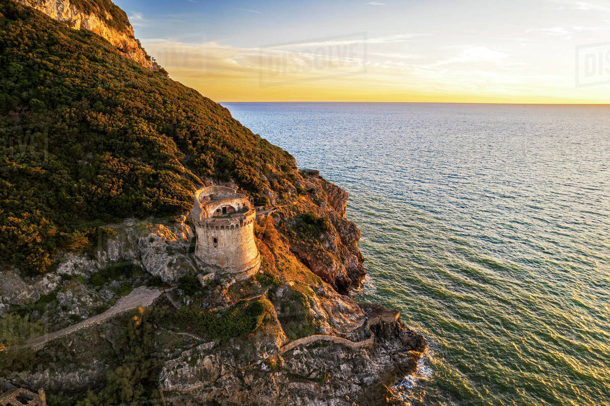 Medieval round tower standing on top of a cliff facing the sea at ...