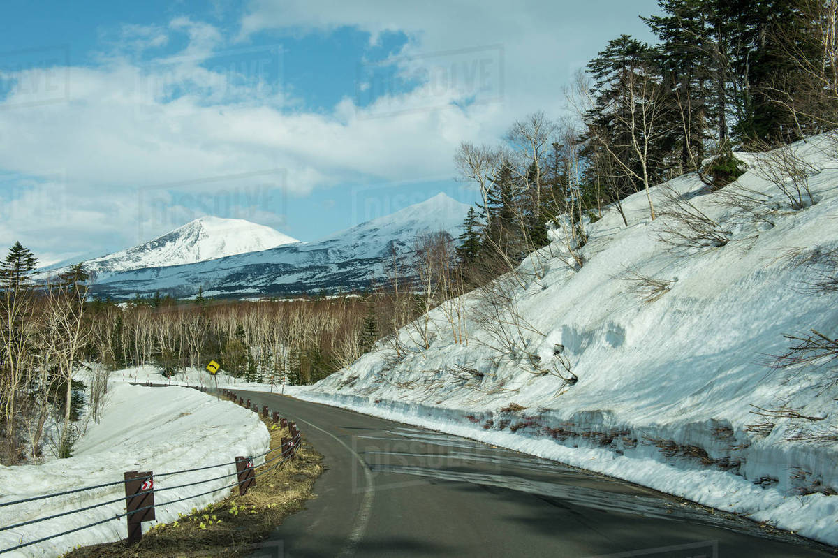 Road leading through the snow capped mountains of the Daisetsuzan ...