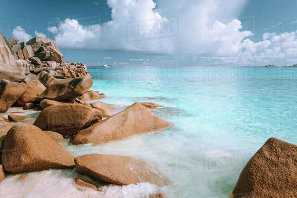 Beautifully shaped granite boulders and blue lagoon at Grand Anse beach ...
