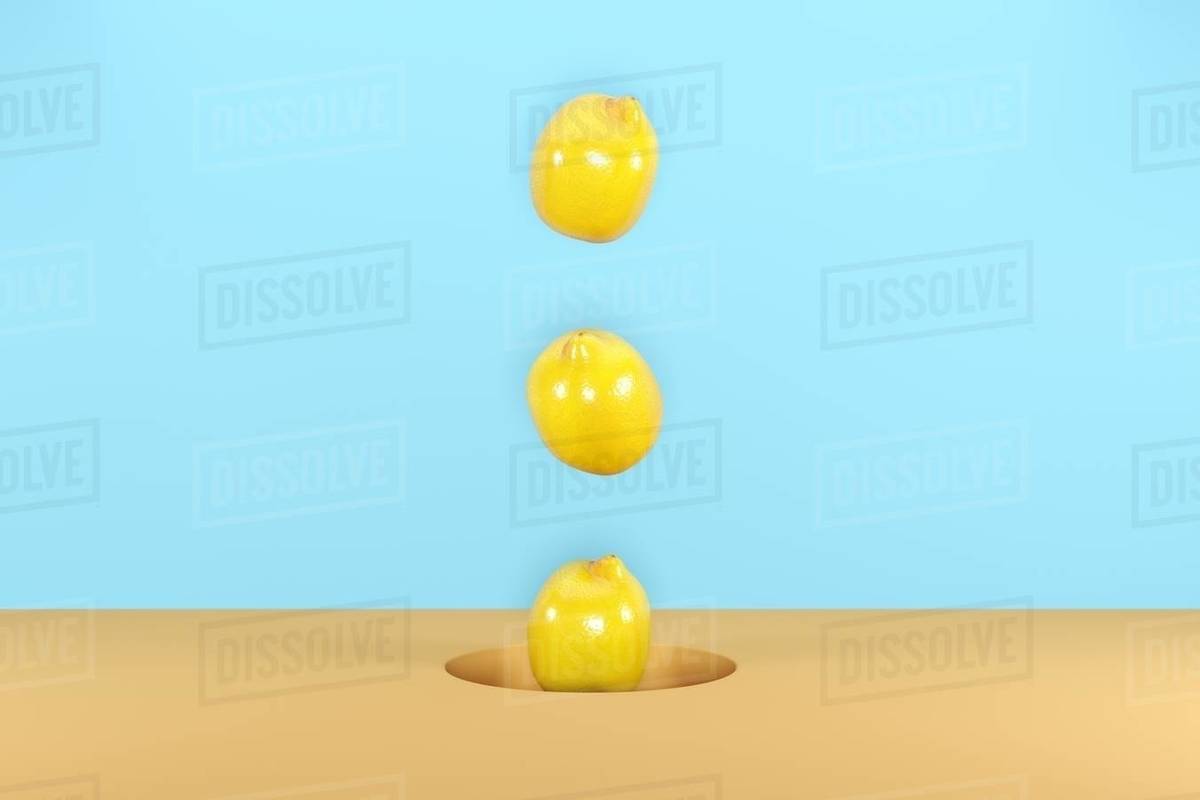 Lemon floating from hole on blue color background. minimal fruits idea ...