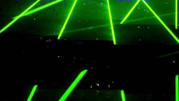 Many people at rave party, green light lazer beam lattice, view from ...