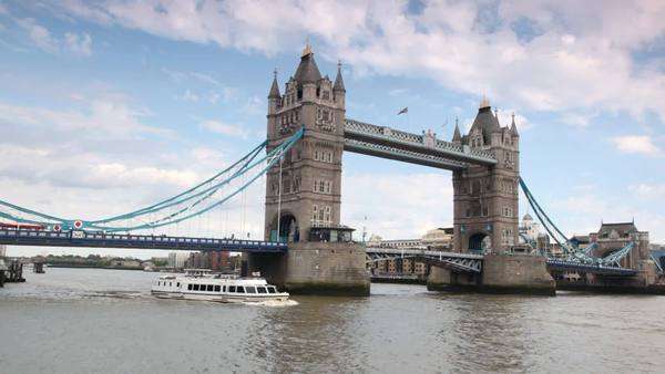 Excursion boat slowly going under magnificent Tower Bridge in London ...