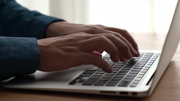 Businessman hand works on capable laptop computer at office table close ...