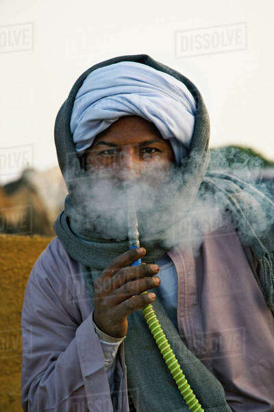 Egyptian camel trader smoking hookah pipe, camel market, Cairo, Egypt ...
