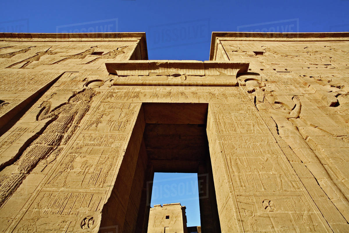 Skyward view of entry pylons and giant figures, Temple of Philae, on ...