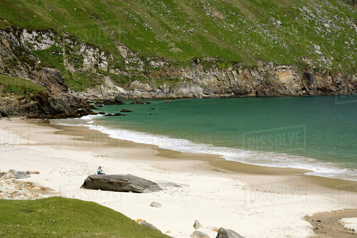 Ireland, County Mayo, Achill Island, Keem Strand. A lone female sun ...