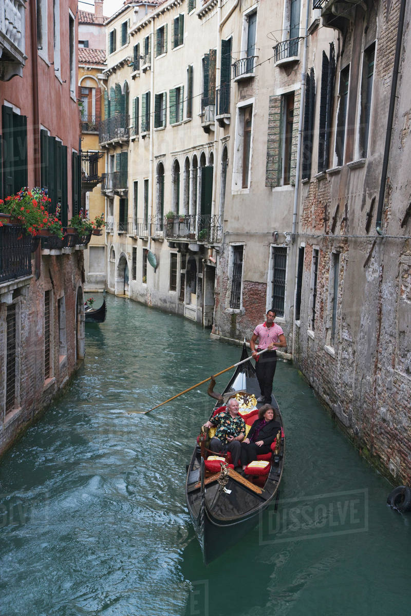 Italy, Venice. Couple takes gondola ride through canals. - Stock Photo ...