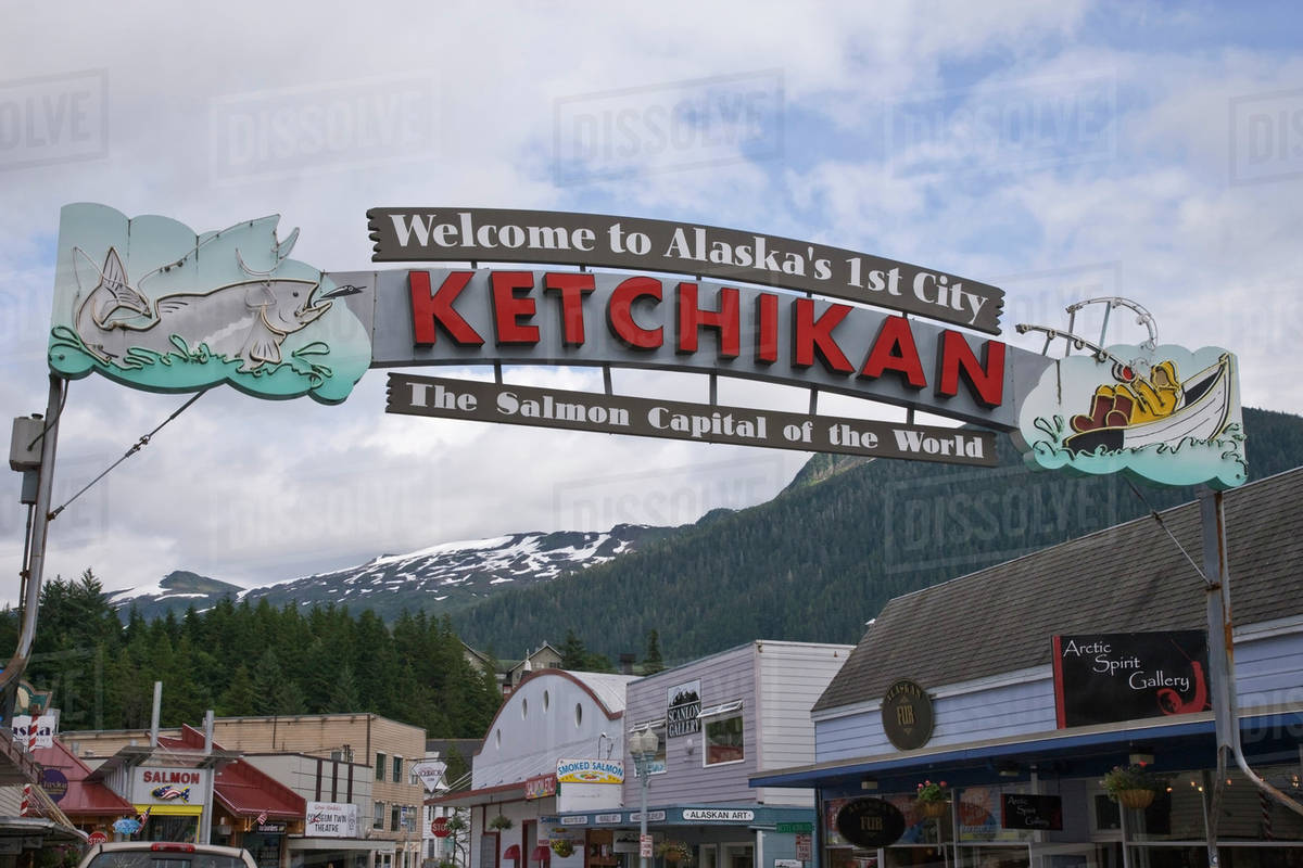 USA, Alaska, Ketchikan. Welcome sign spans street lined with stores ...
