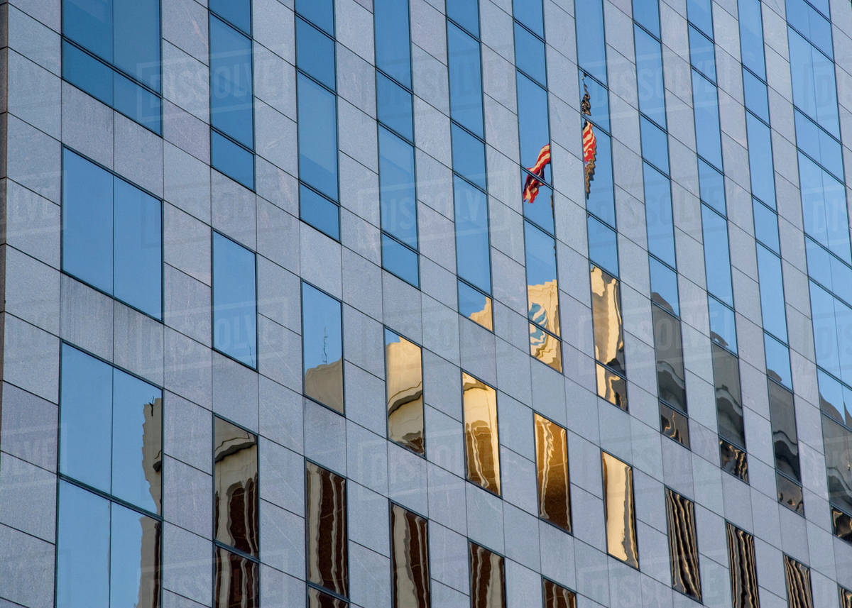 USA, Louisiana, New Orleans. American flag atop building reflected in ...