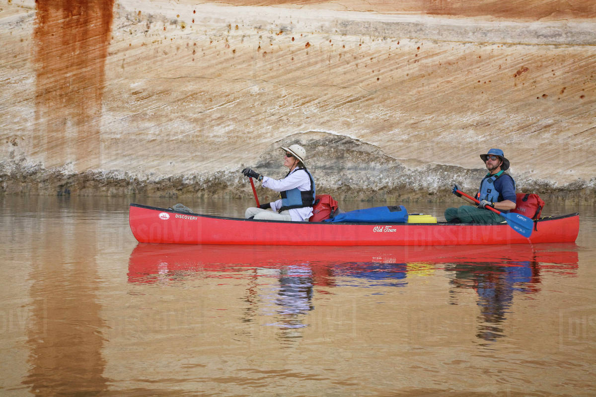 USA, Utah, Canyonlands National Park. Man and woman paddle canoe on ...