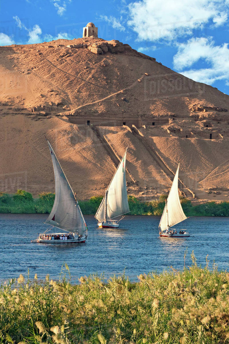 Egypt, Aswan, Nile River, Felucca sailboats, temple ruins and the large ...