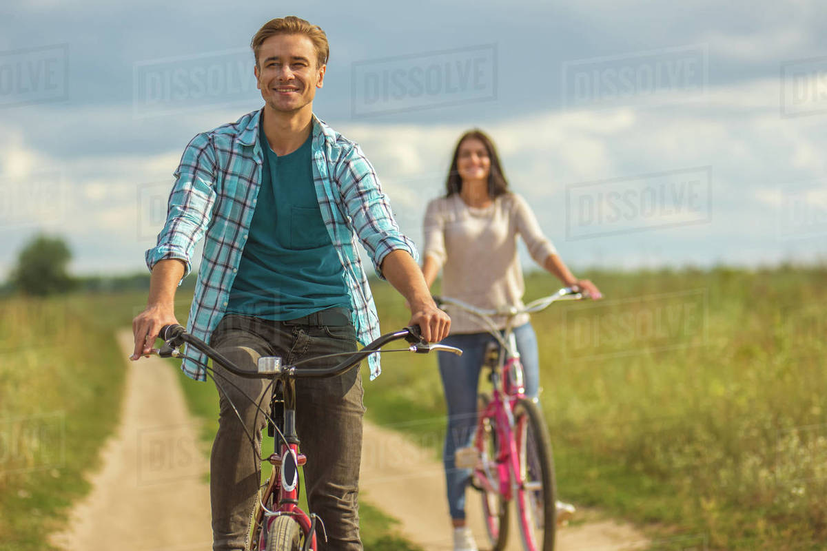 Man and woman riding bikes on a country road - Royalty-free Stock Photo ...