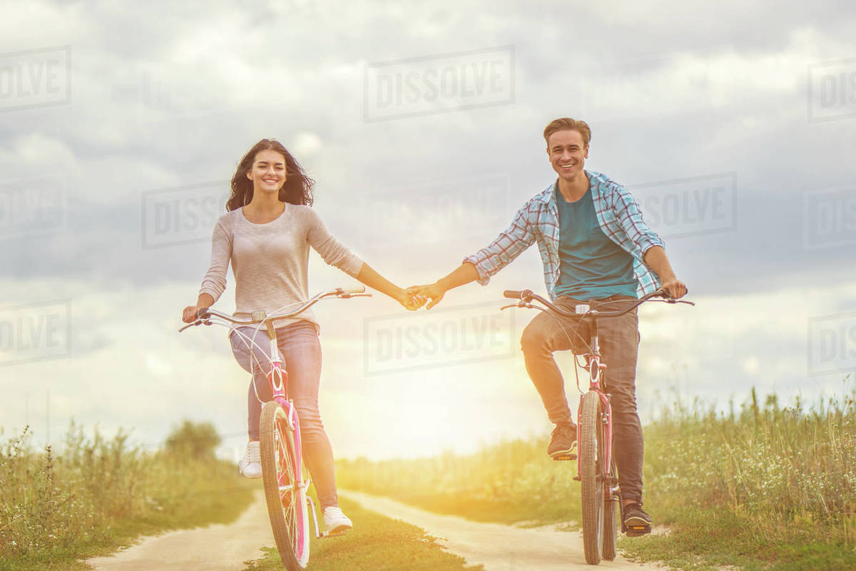 Man and woman riding bikes on a country road - Royalty-free Stock Photo ...