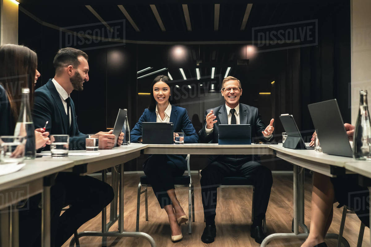 The business people sitting at the table - Stock Photo - Dissolve