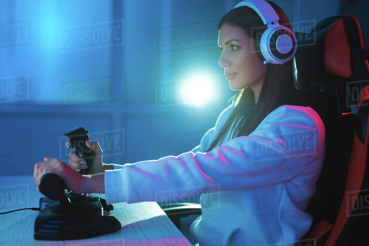 The beautiful gamer girl playing video games at the dark room - Royalty ...