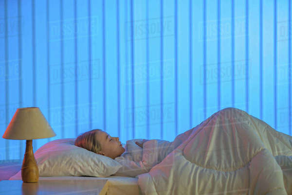 The cute girl sleeping on the bed. Evening night time - Royalty-free ...